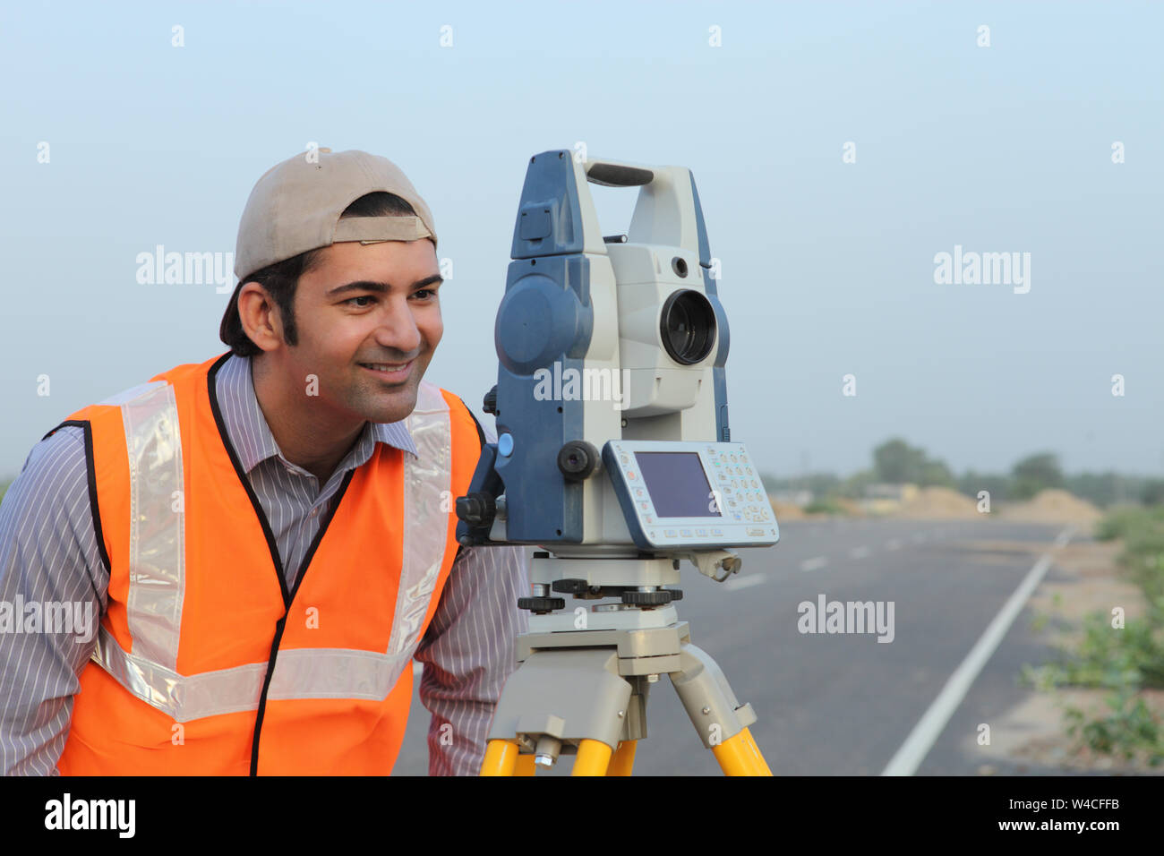 Surveyor using theodolite on tripod Stock Photo - Alamy