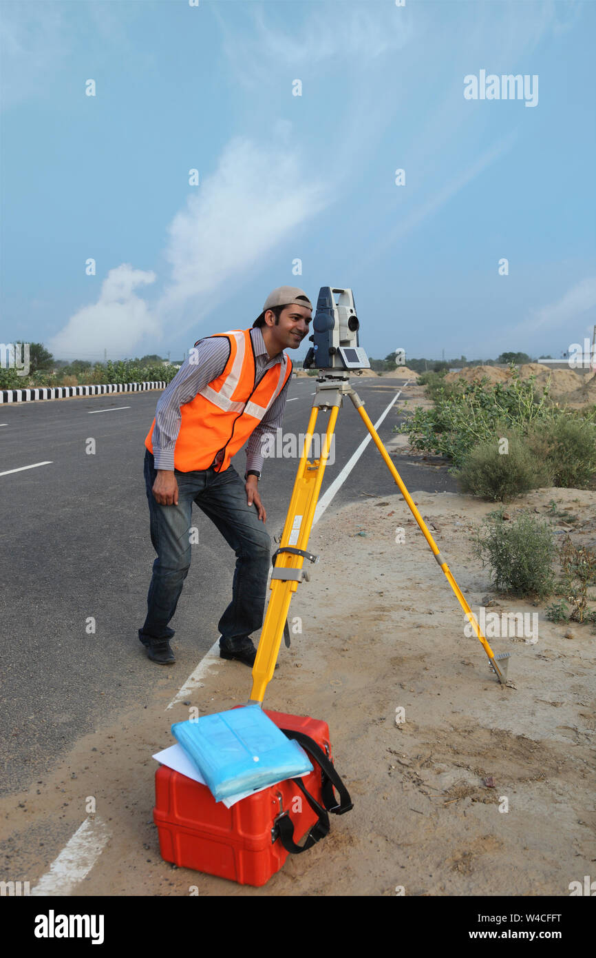 Surveyor using theodolite on tripod Stock Photo - Alamy