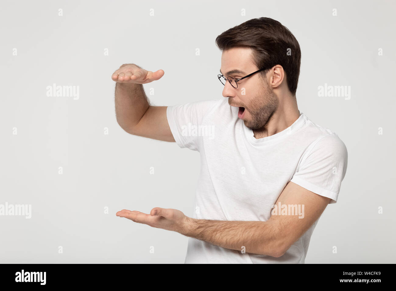 Shocked man show with hands big size feels amazed Stock Photo - Alamy