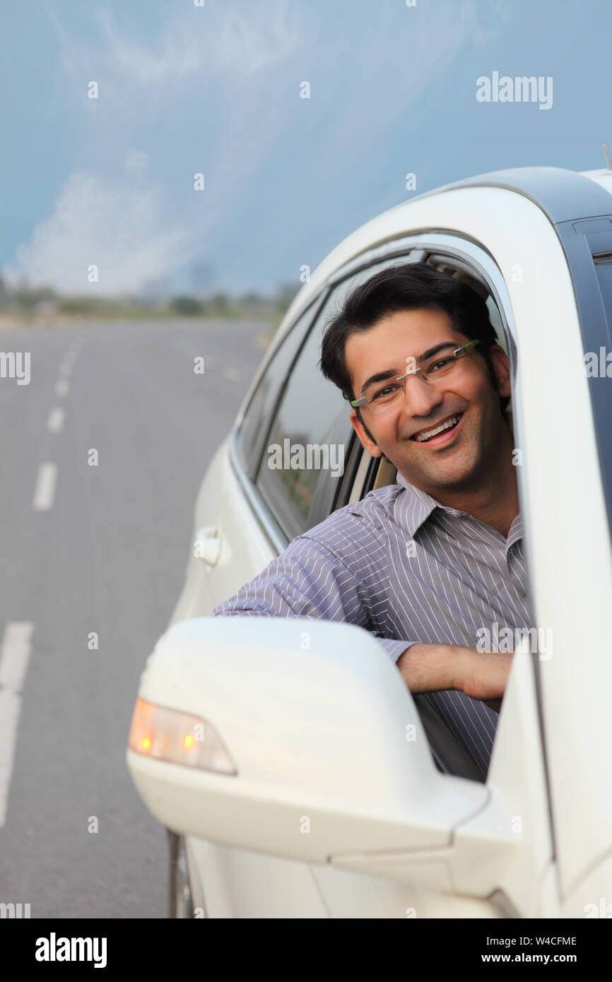 Portrait of a man driving a car and smiling Stock Photo - Alamy