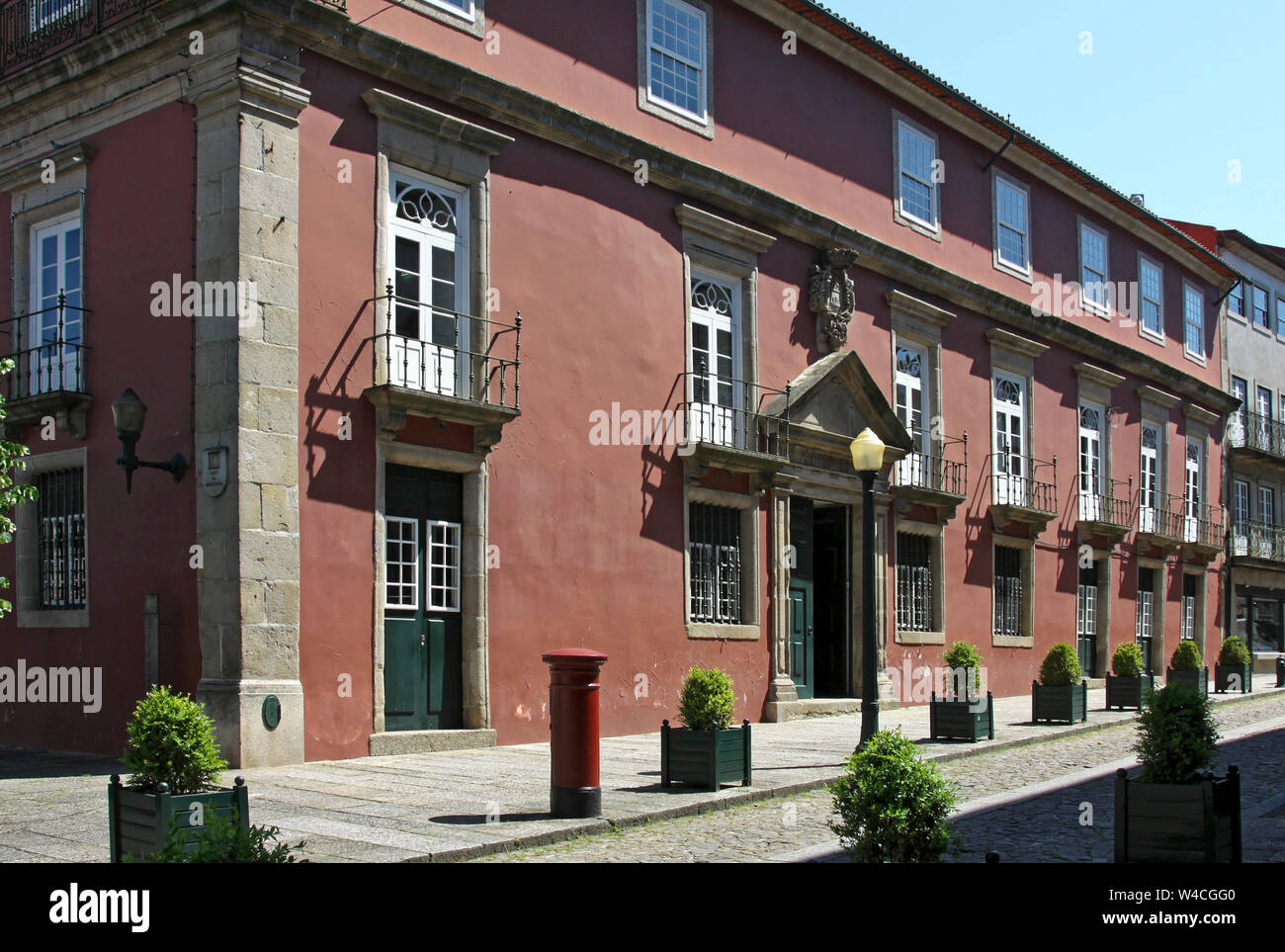 old building, terra cotta color, wrought iron balconies, above door ...