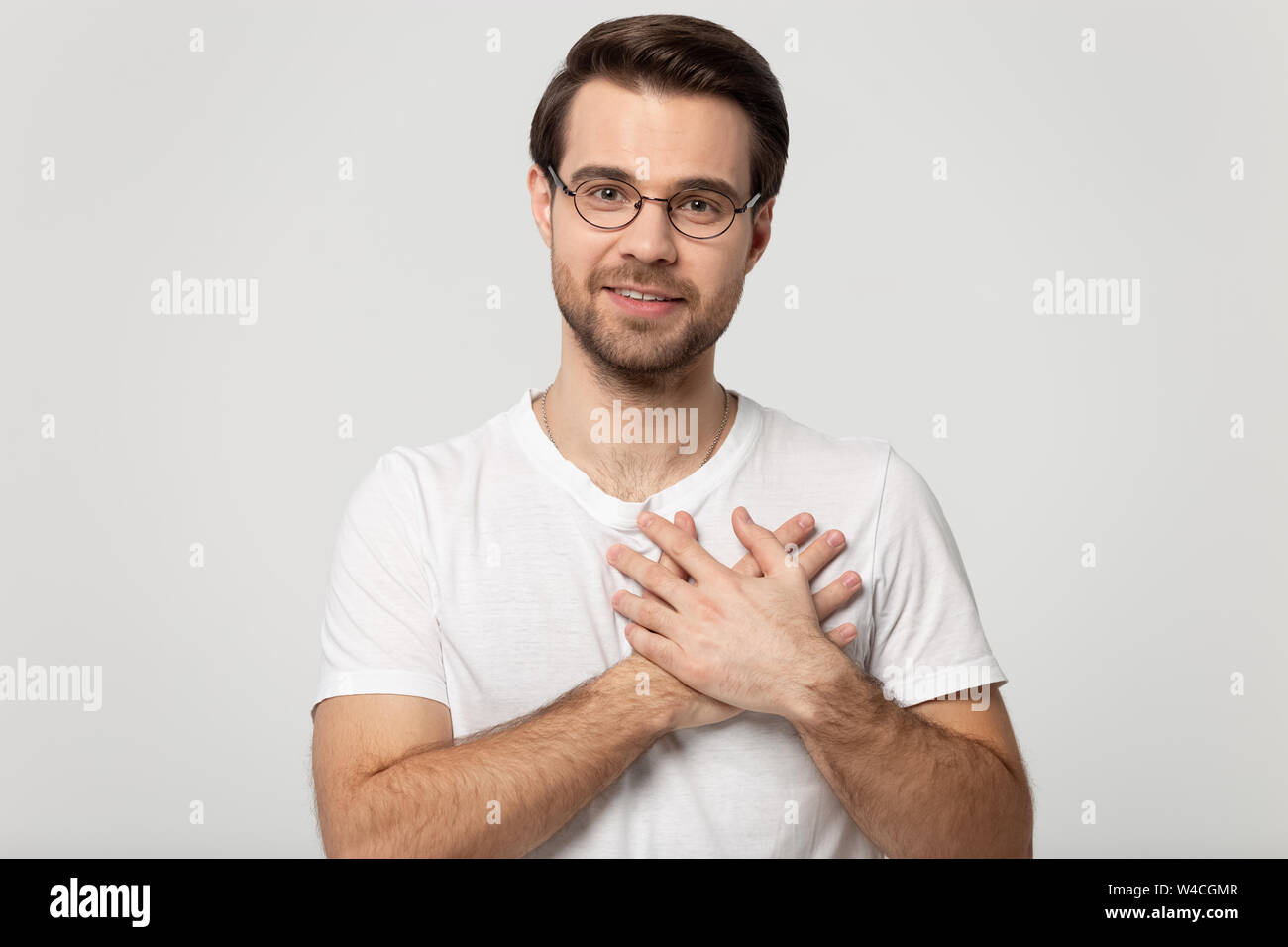 Guy holding hands on chest symbol of gratitude studio shot Stock Photo ...