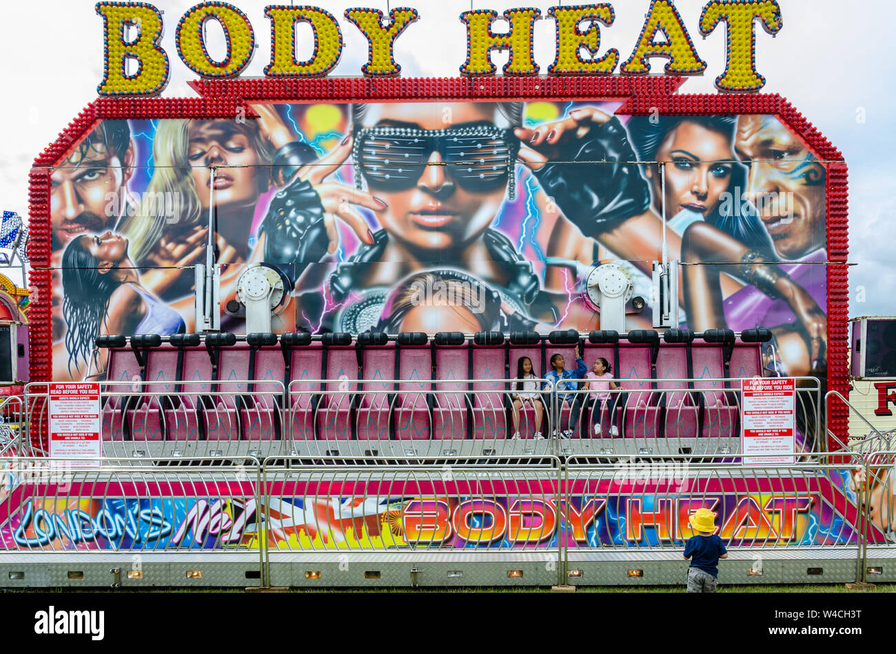 Three young girls ride alone on an attraction at a fair ground Stock ...