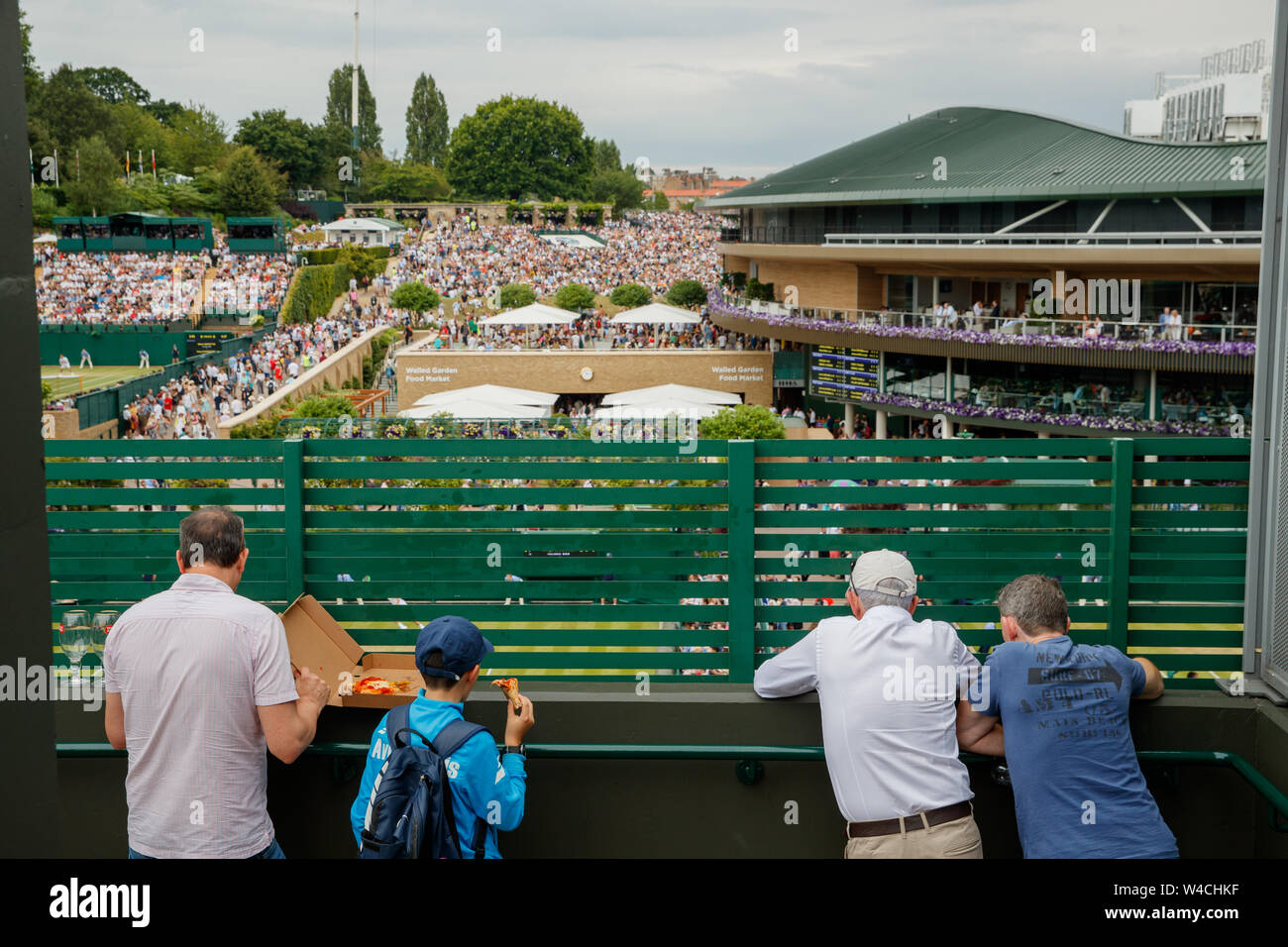 Fans watching action on Court through slated fence at Wimbledon ...