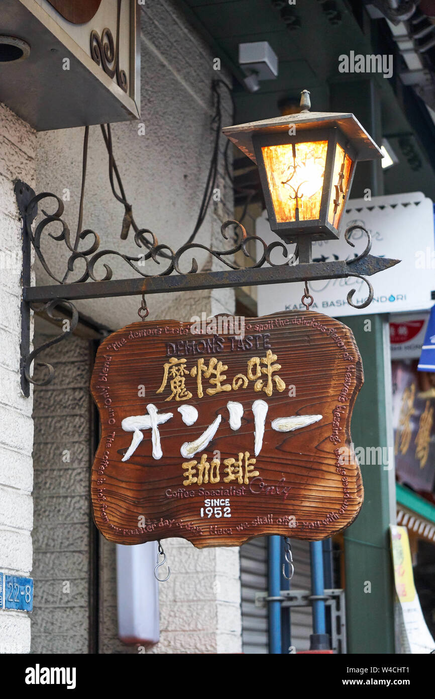 A wooden sign hangs in front of the coffee shop Coffee Specialist Only ...