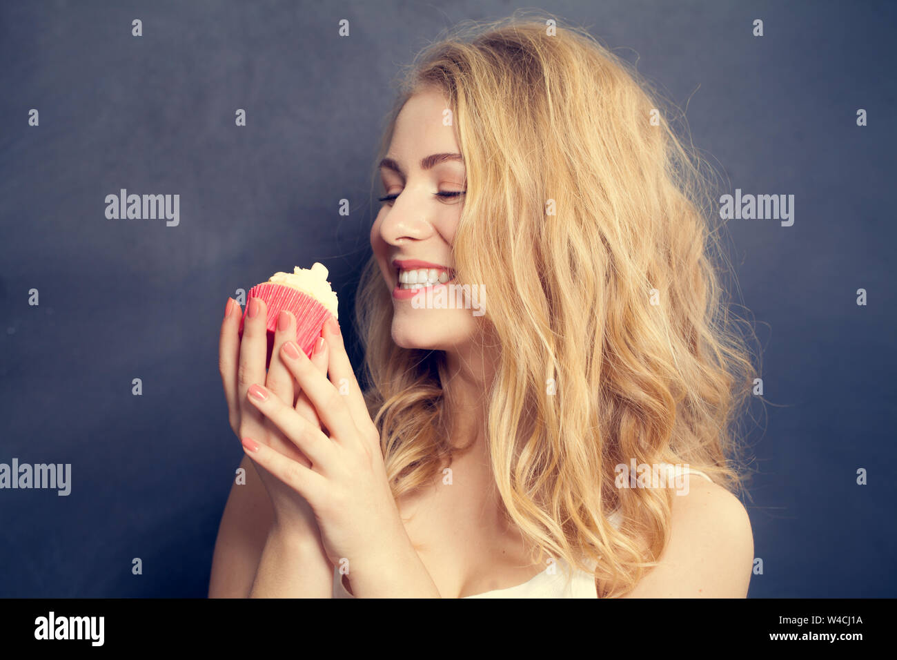 Happy smiling cute woman eat sweet cake on black background Stock Photo ...