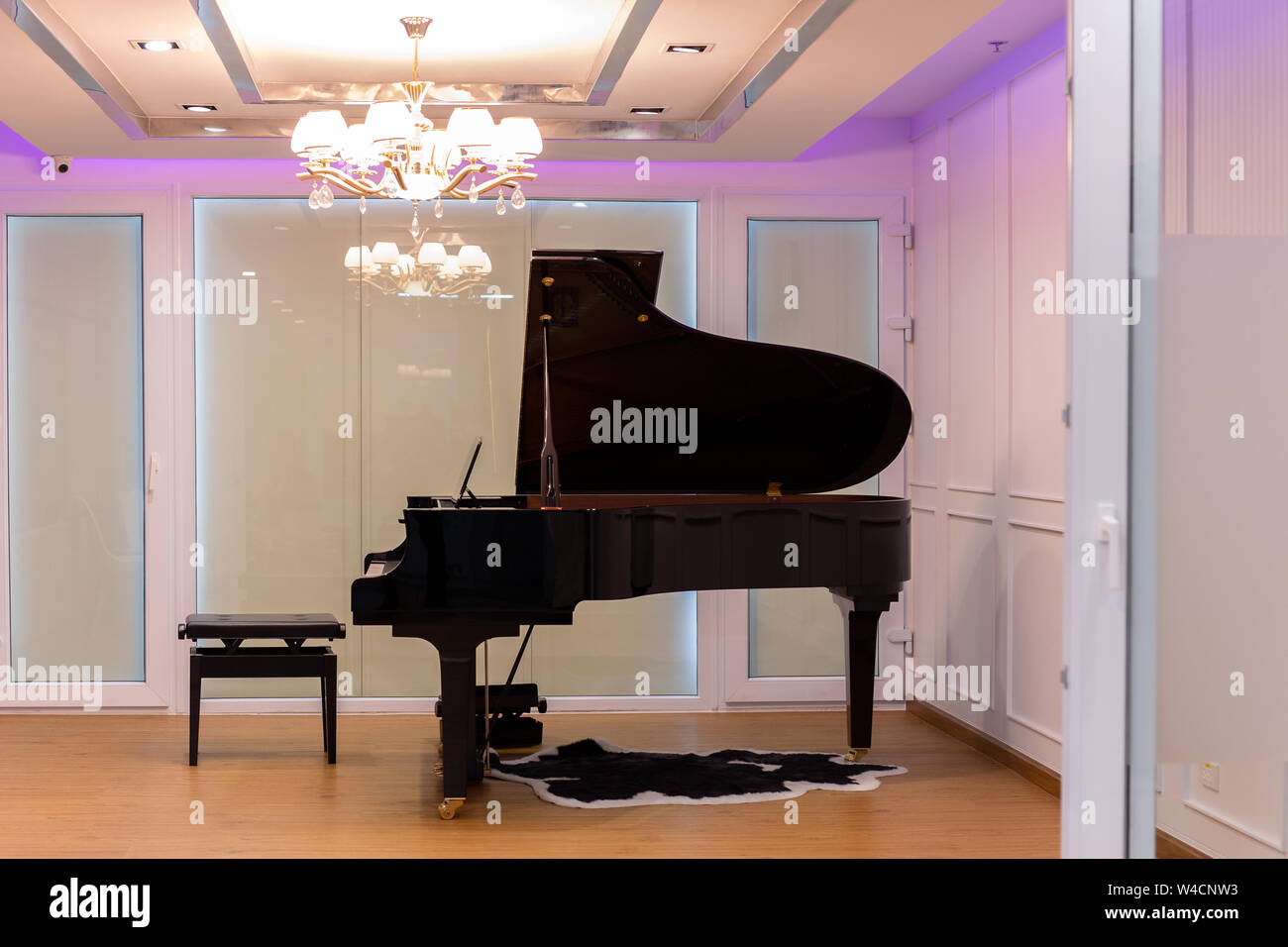 Luxurious music room with grand piano and chandelier with colorful ...