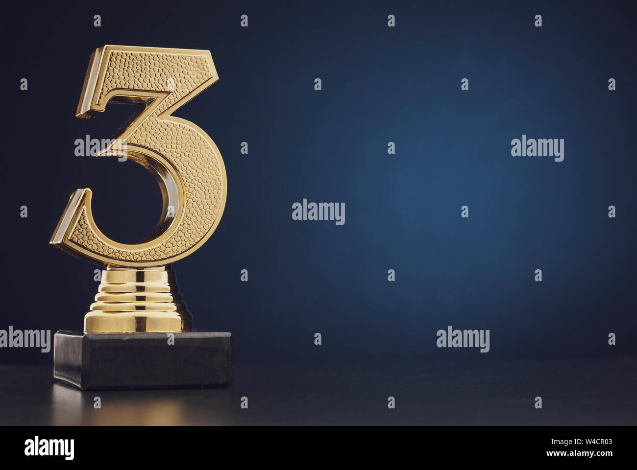 Sharp close up on single isolated gold colored plastic statue of number ...