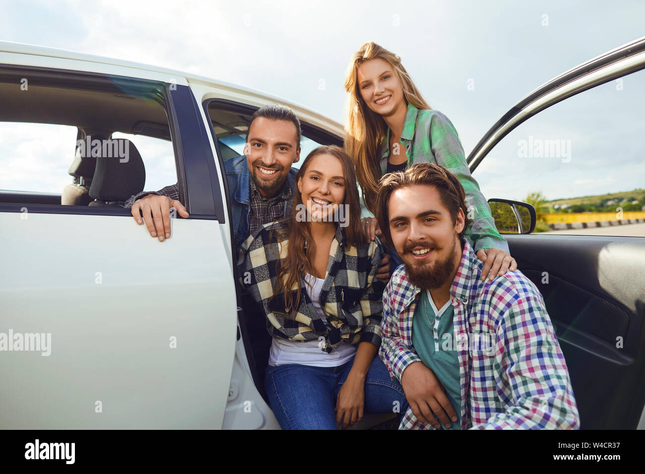 Group of people standing next travel in the car on road Stock Photo - Alamy