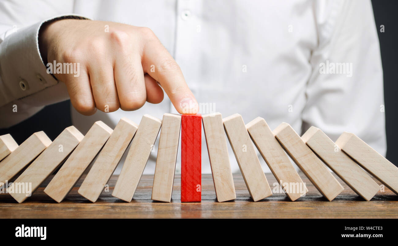 Businessman stops collapse domino effect. Stress resistance business ...