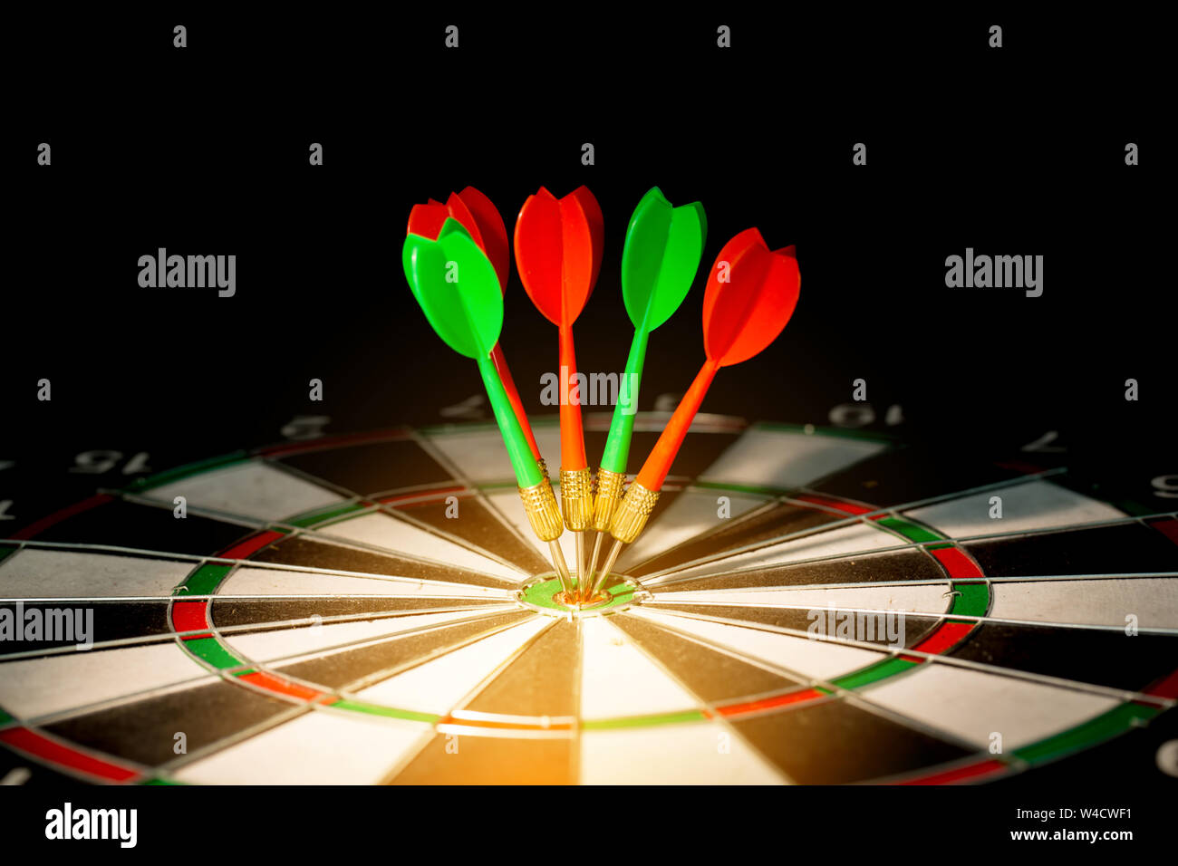 red darts hitting the center of target on black background Stock Photo ...