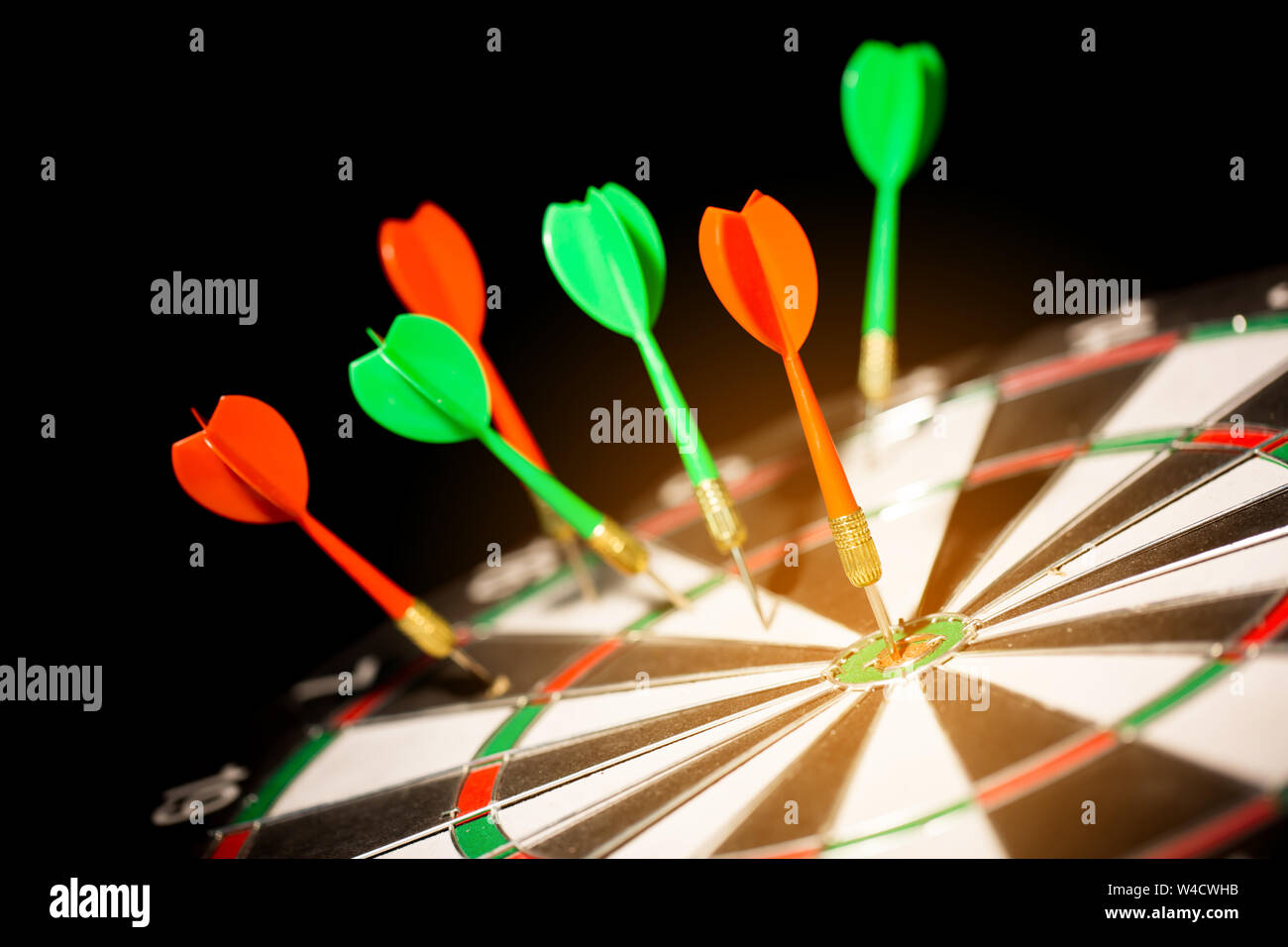 red darts hitting the center of target on black background Stock Photo ...