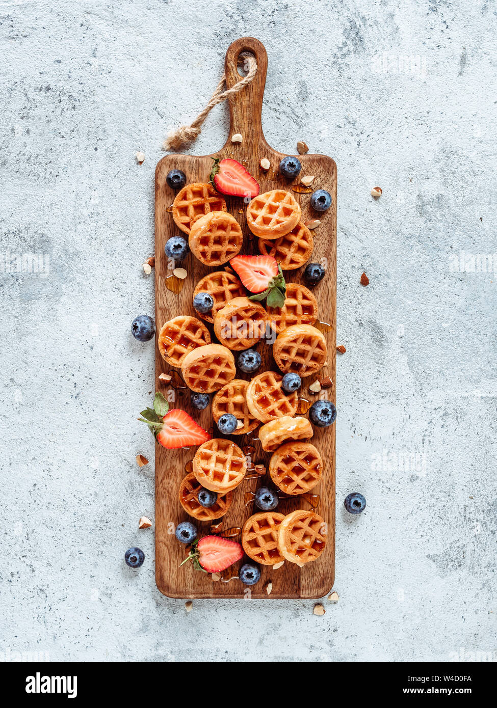 Small round delicious soft belgian waffles on cutting board. Fresh ...
