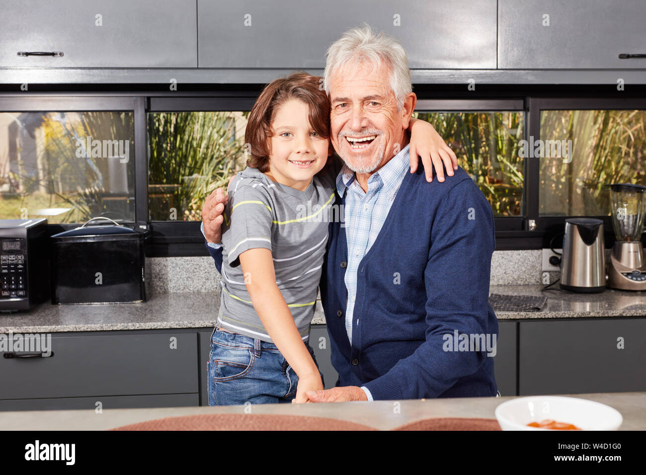 Laughing grandfather as a happy grandpa together with his grandson in ...