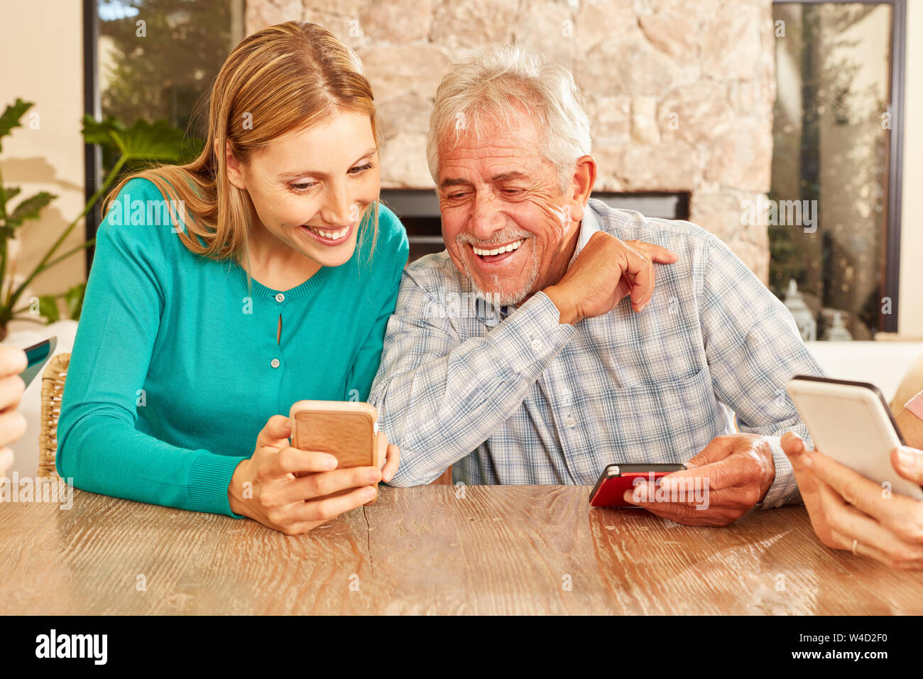 Woman shows senior a text message on the smartphone or explains the ...