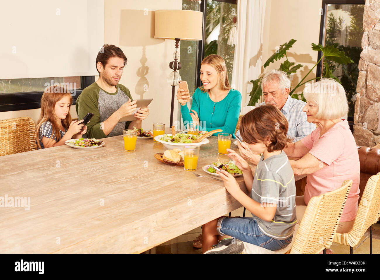 Extended family with three generations sitting at the dining table with ...