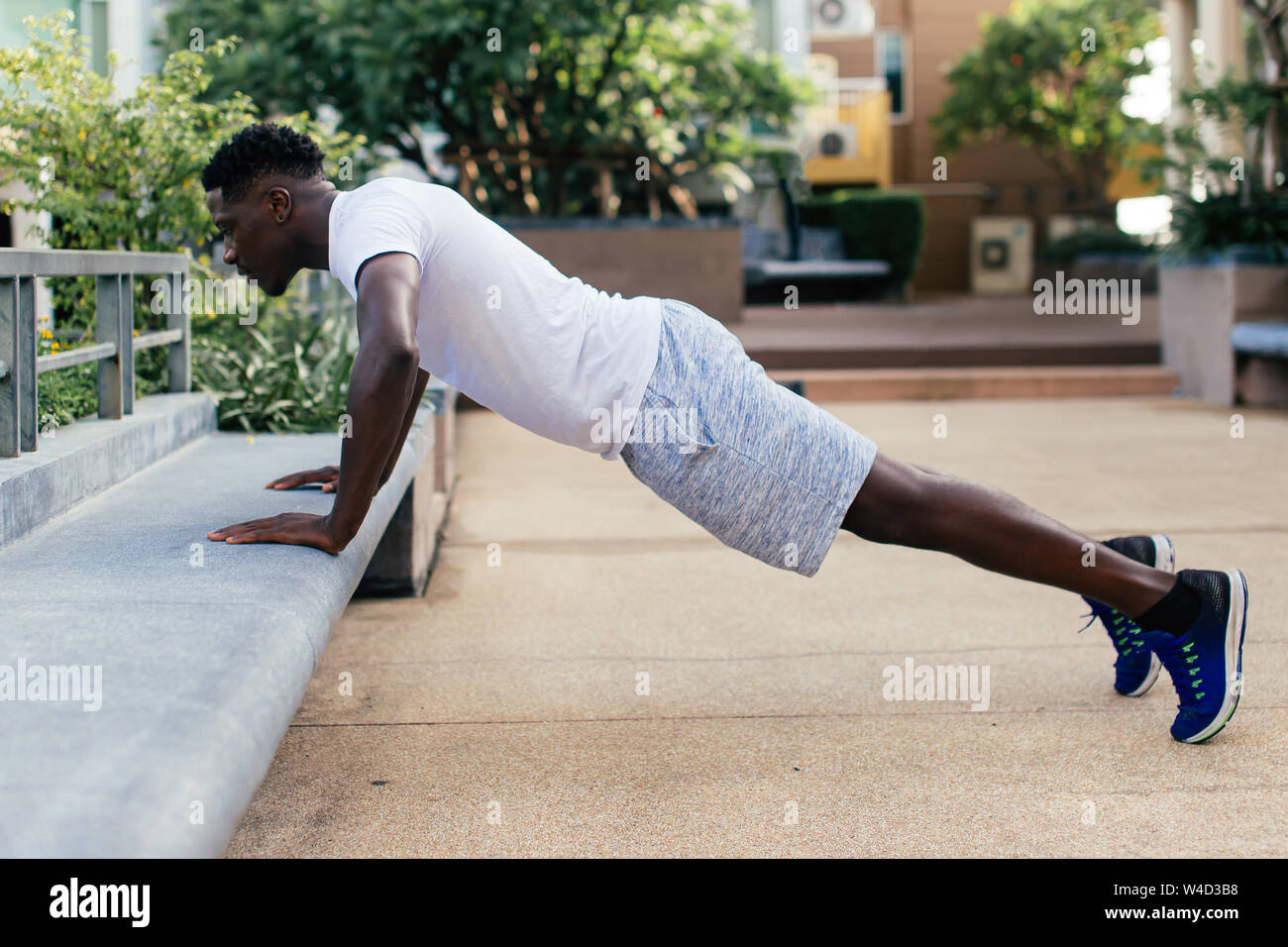Young African American man doing push up in city park. Male sporty ...
