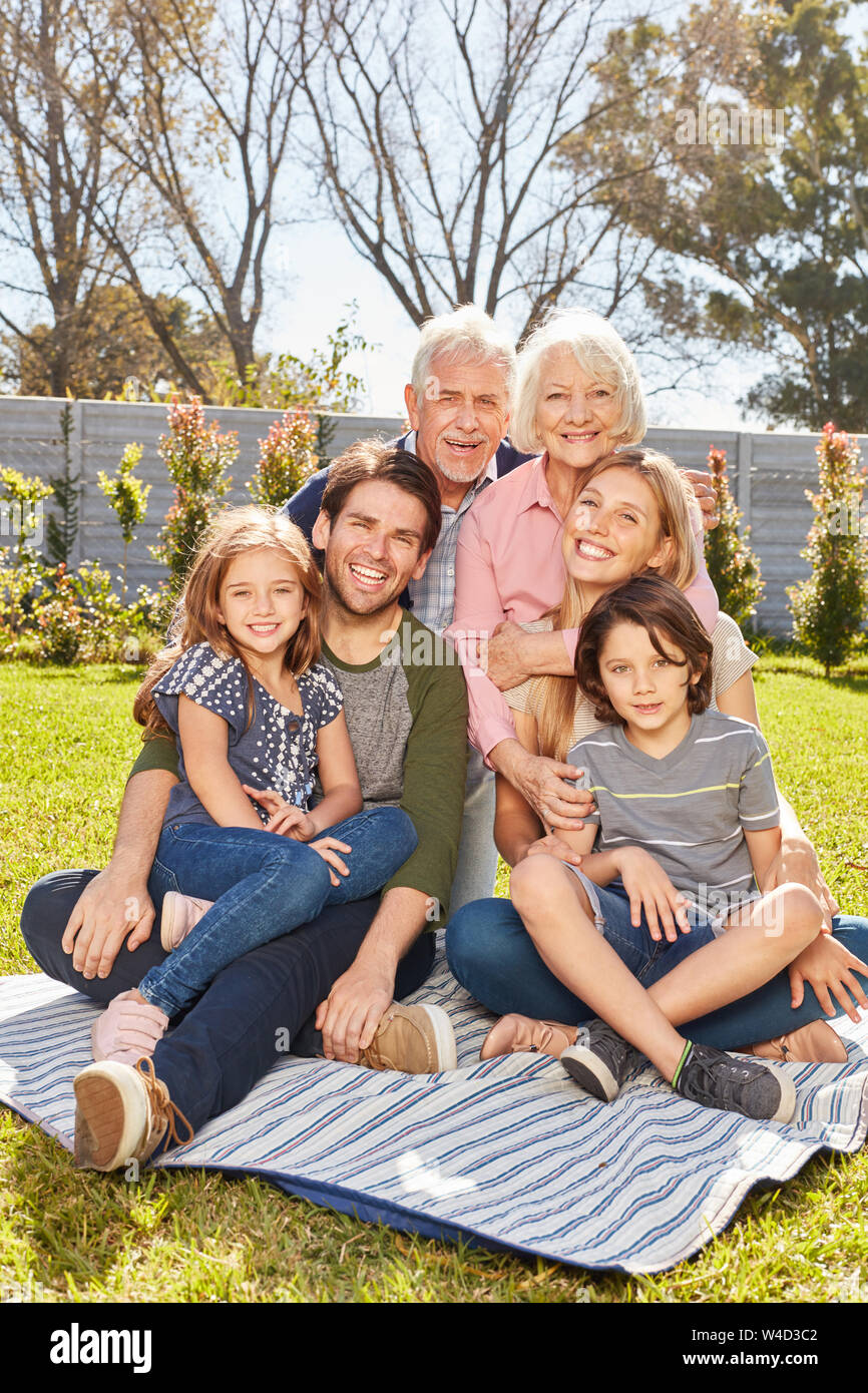 Three generations of a family are sitting happily together in the ...