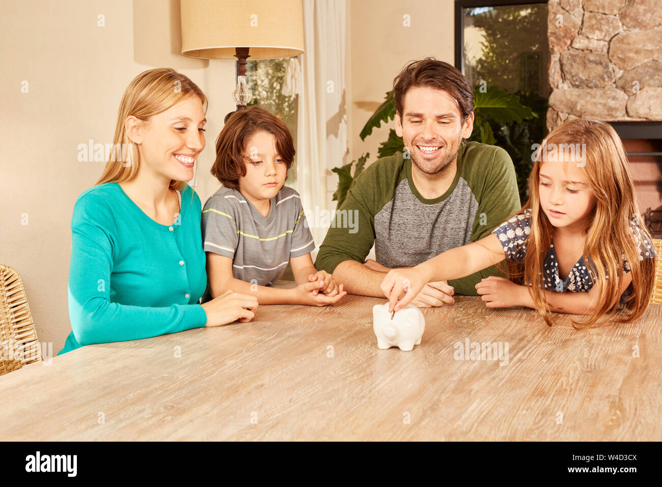 Parents and children put money into a piggy bank and save for the ...