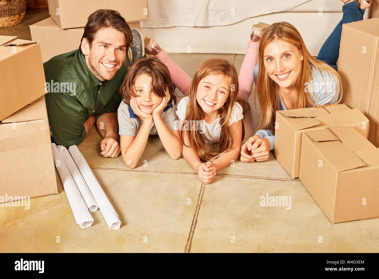 Happy family with two kids in new home between moving boxes Stock Photo ...