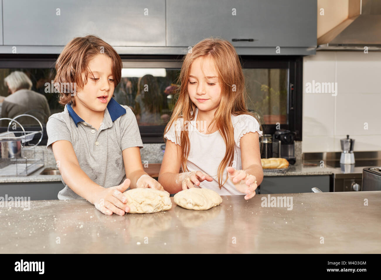 Siblings do household chores in kitchen hi-res stock photography and ...