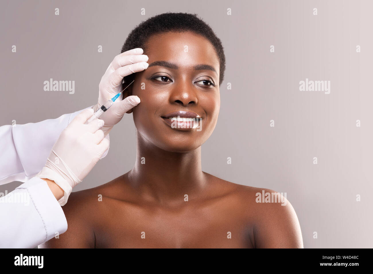Young black woman getting beauty injection under skin Stock Photo - Alamy