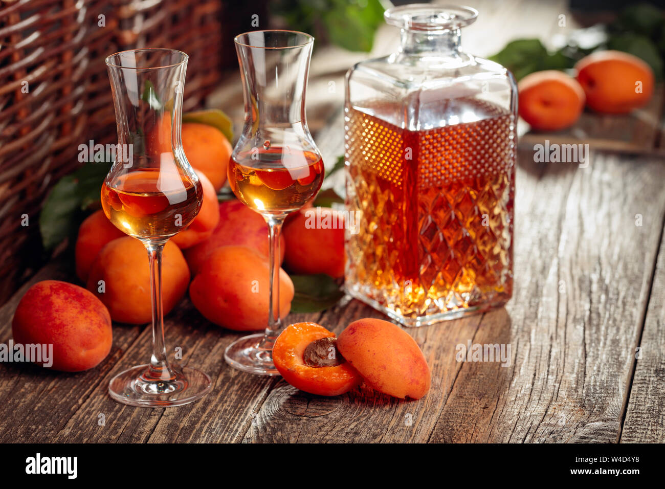 Apricot liquor and fresh apricots on a old wooden table. Wine and juicy ...