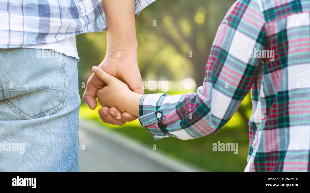 Father holds daughter by the hand while walking Stock Photo - Alamy