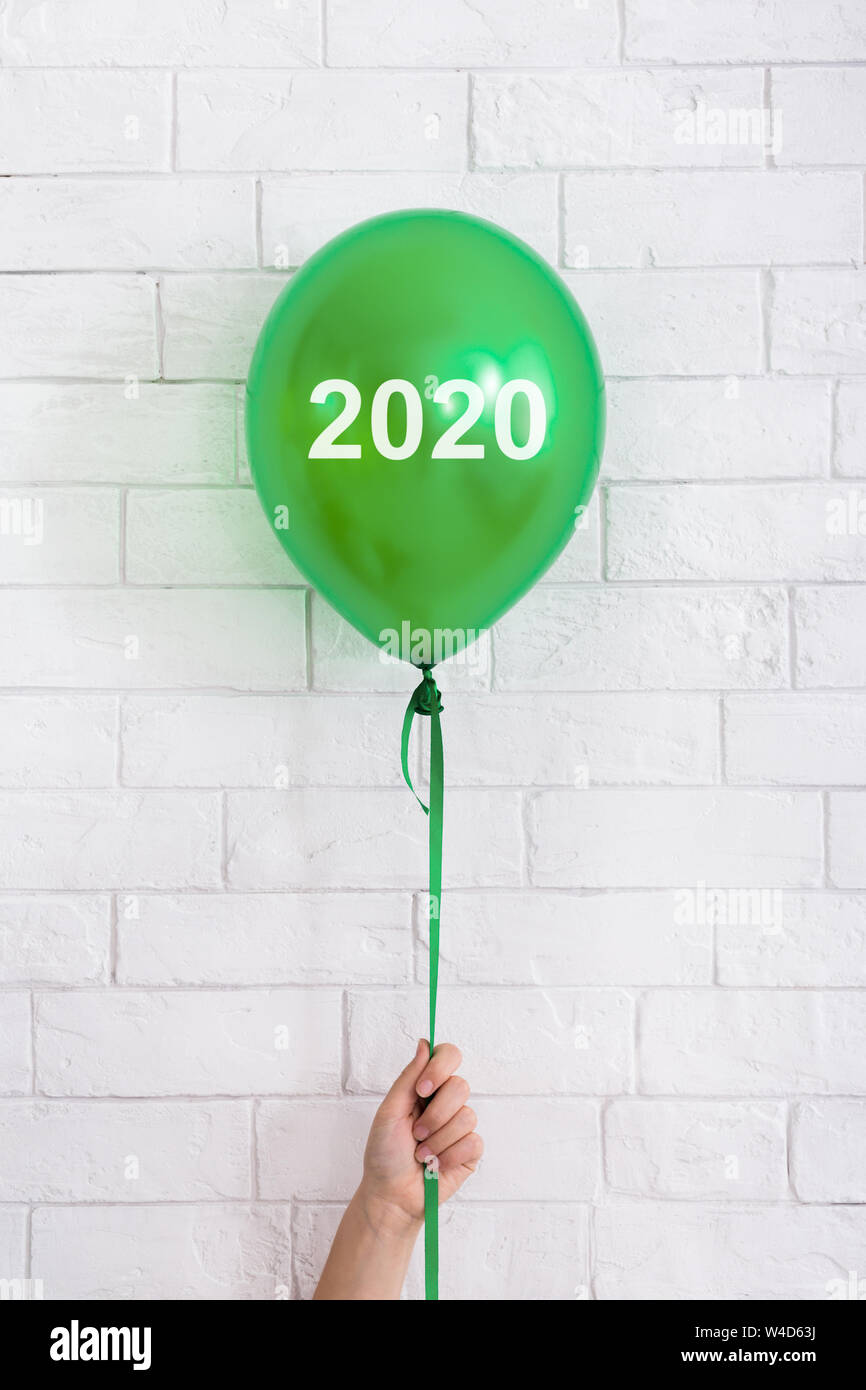 Bright green balloon with 2020 concept in woman hand on white Stock ...