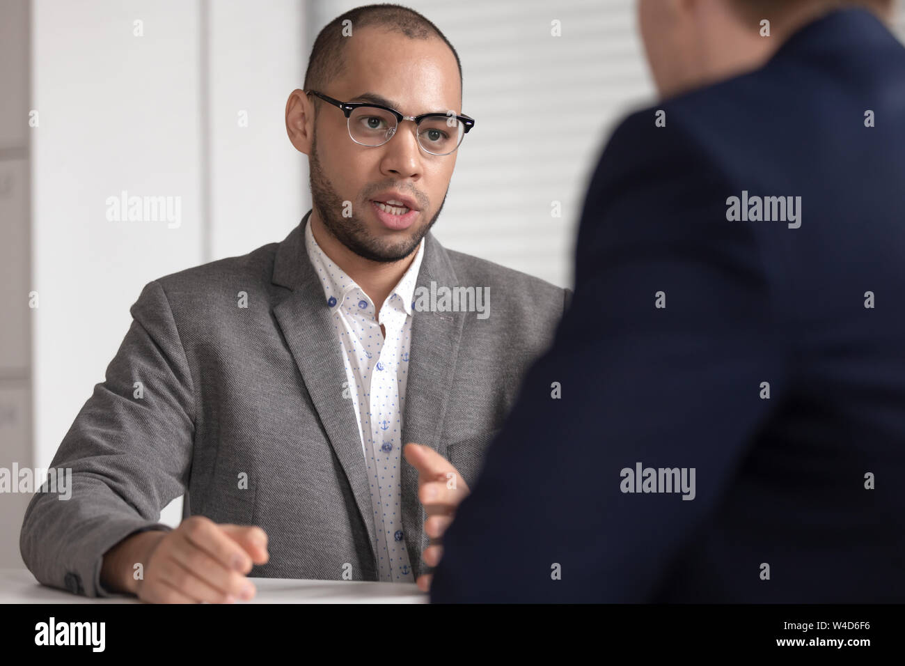 Serious african bank insurance broker lawyer in suit consulting client ...