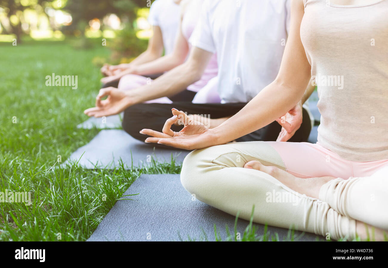 Close up of cropped people sitting in lotus position outdoors Stock ...