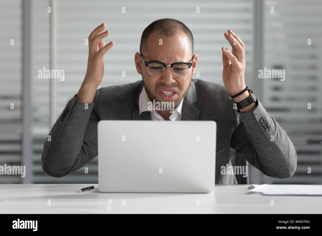 Angry african business man using laptop mad about computer problem ...