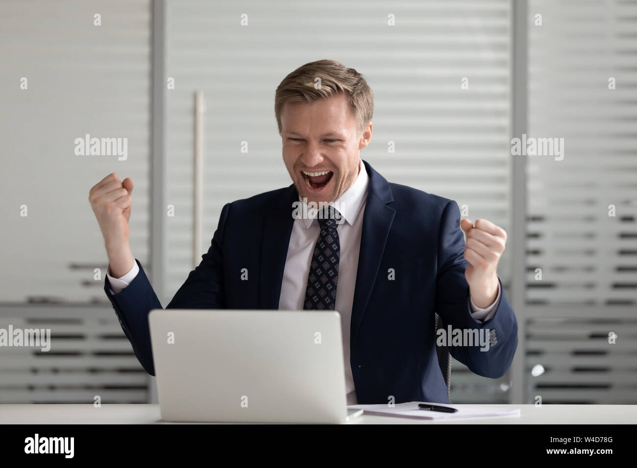 Happy excited businessman triumphant winner wearing suit looking at ...