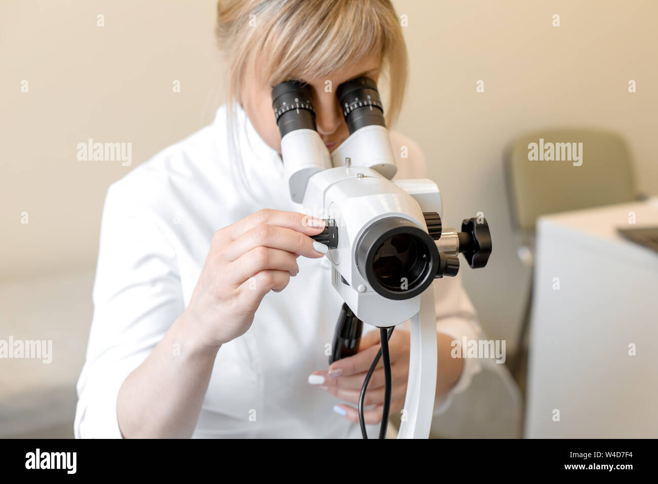 Young female professional gynecologist in the working process, looks ...