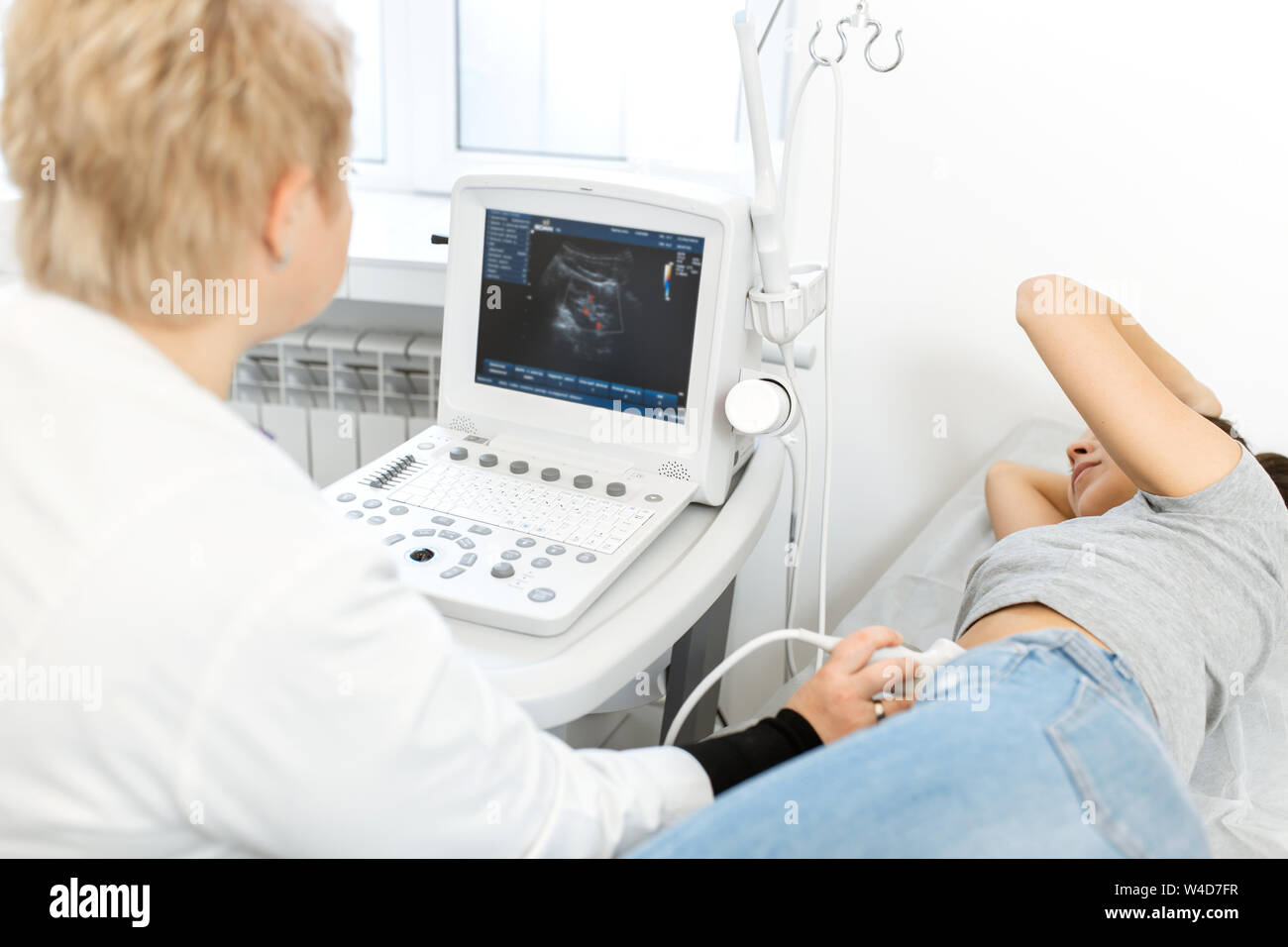 The doctor is preparing to conduct ultrasound research. smears the gel ...