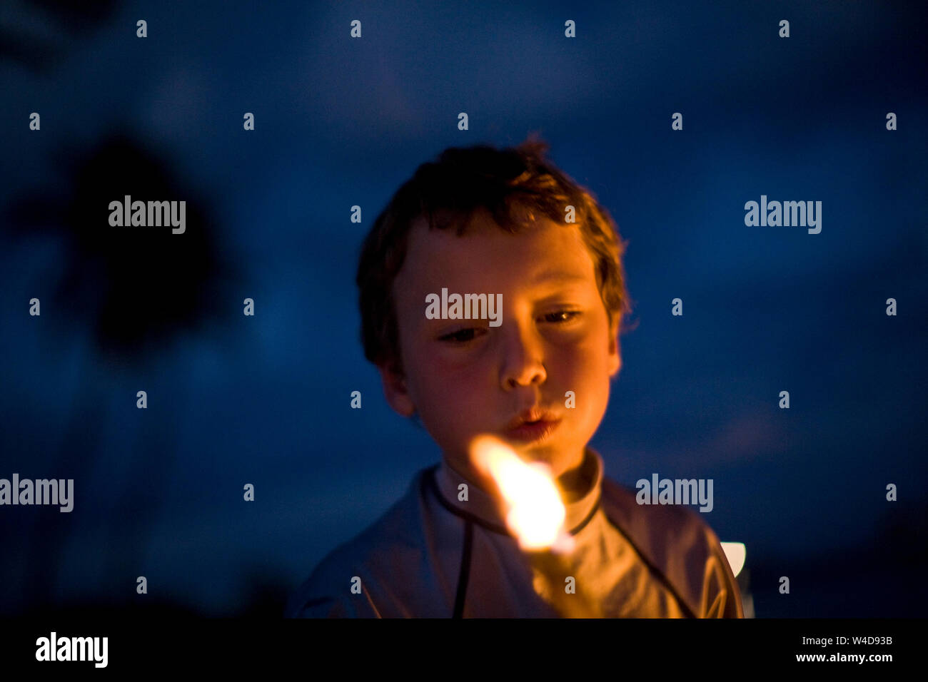 Boy blowing on a flame Stock Photo - Alamy