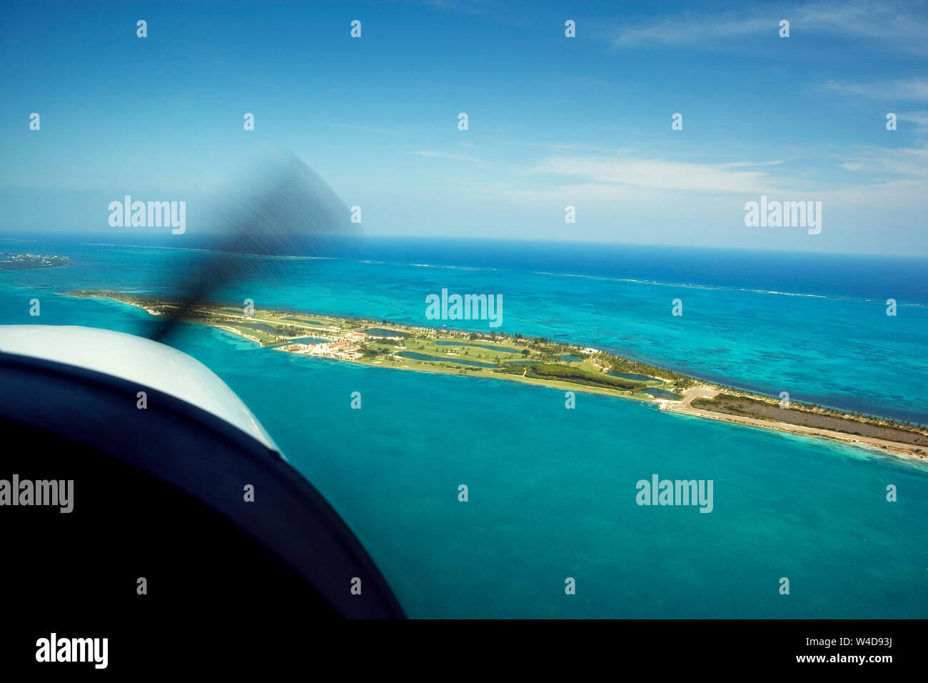Plane flying over a tropical island Stock Photo - Alamy