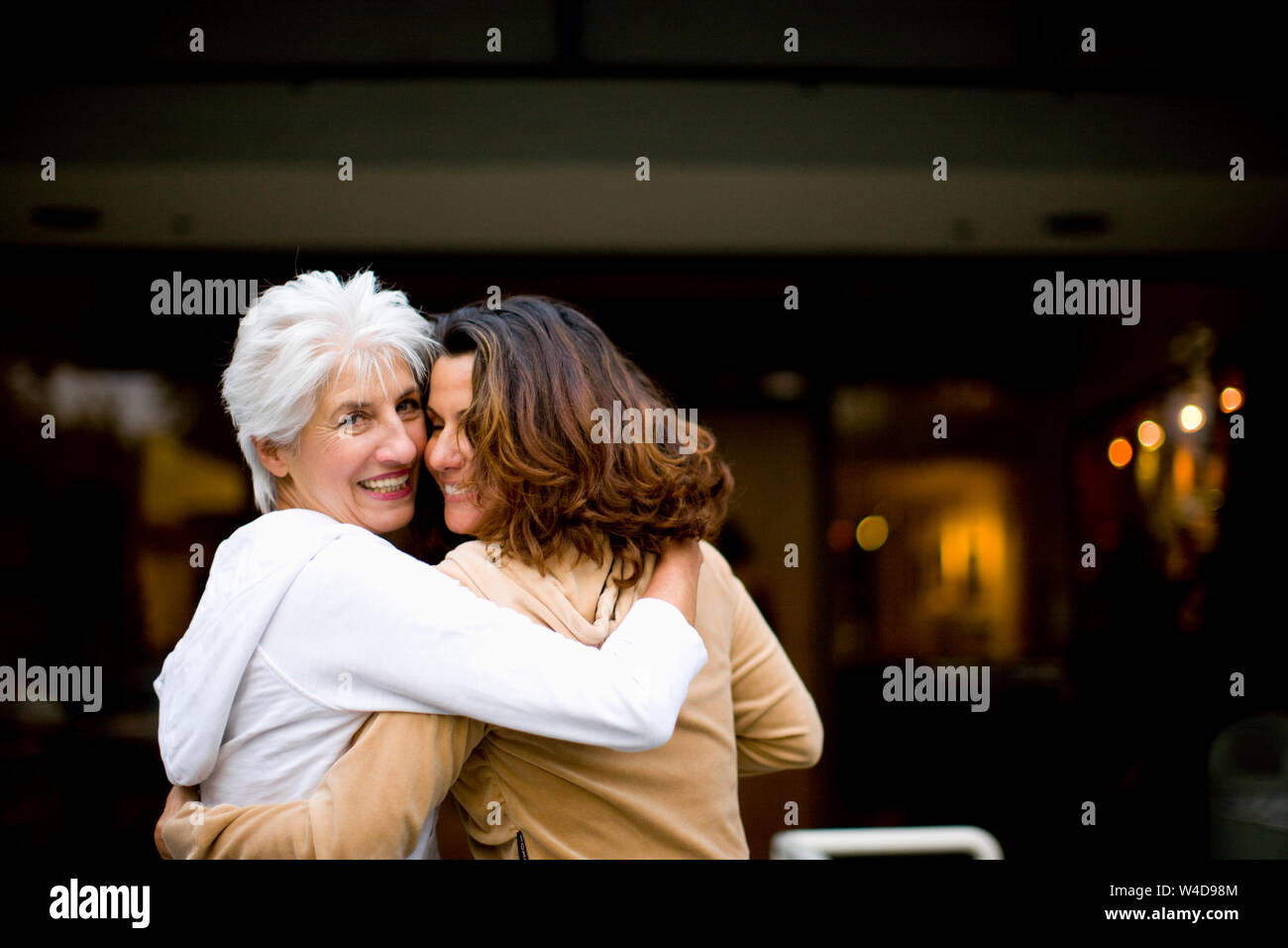 Portrait of two smiling women with arms around each other Stock Photo ...