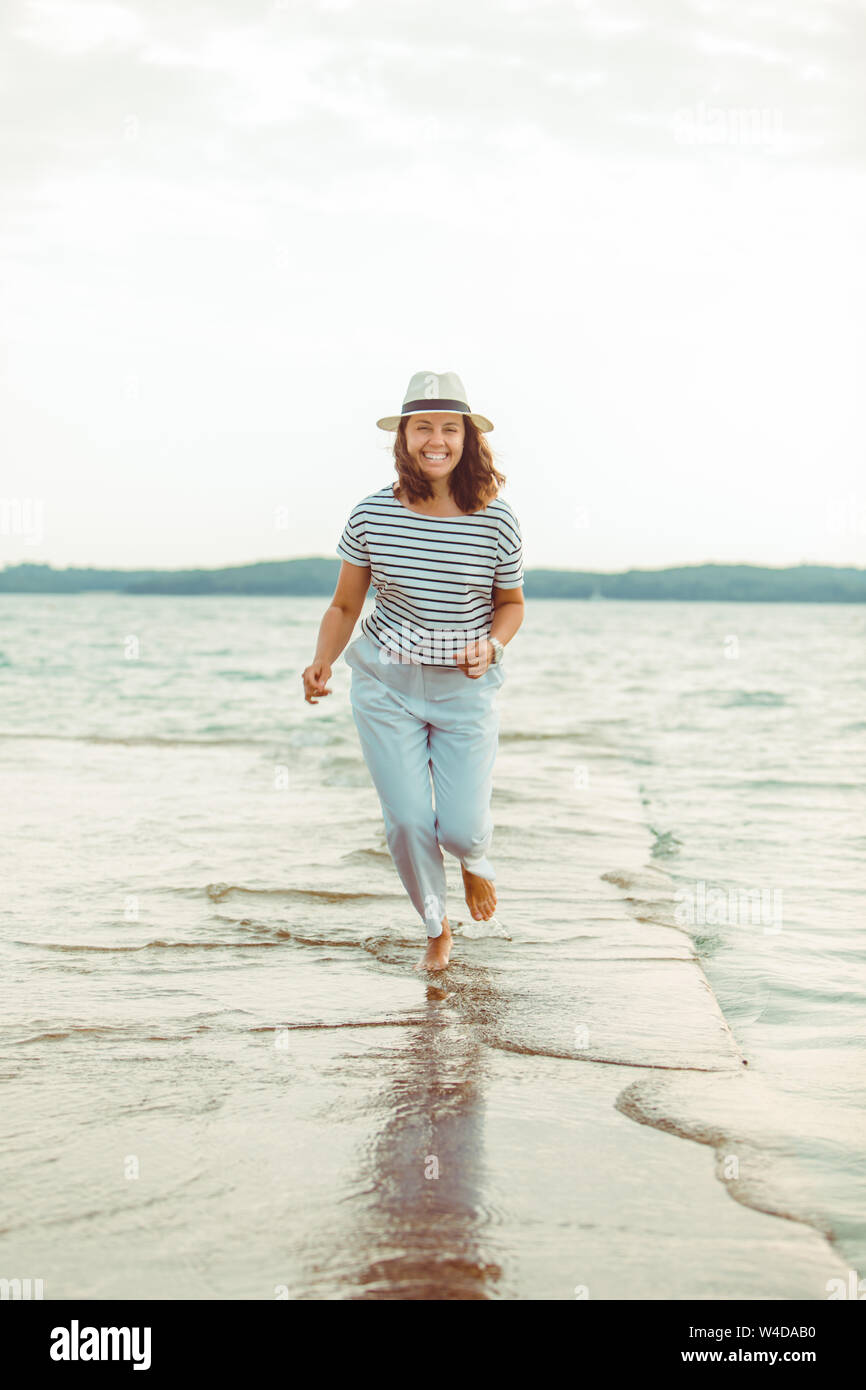woman in white clothes walking by sea beach summer time Stock Photo - Alamy