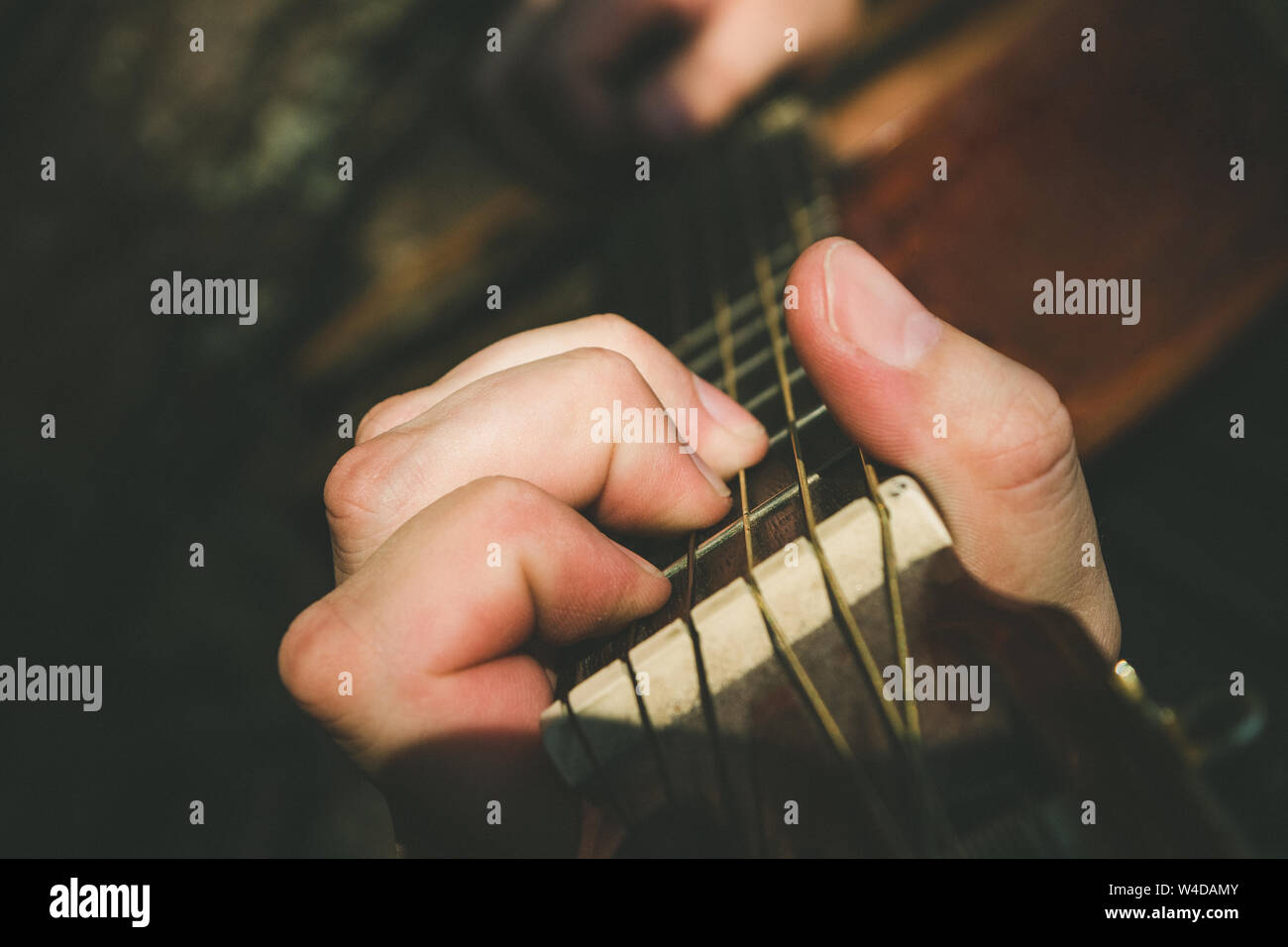 Fingers forming a chord on a guitar fingerboard. Male hand playing on ...