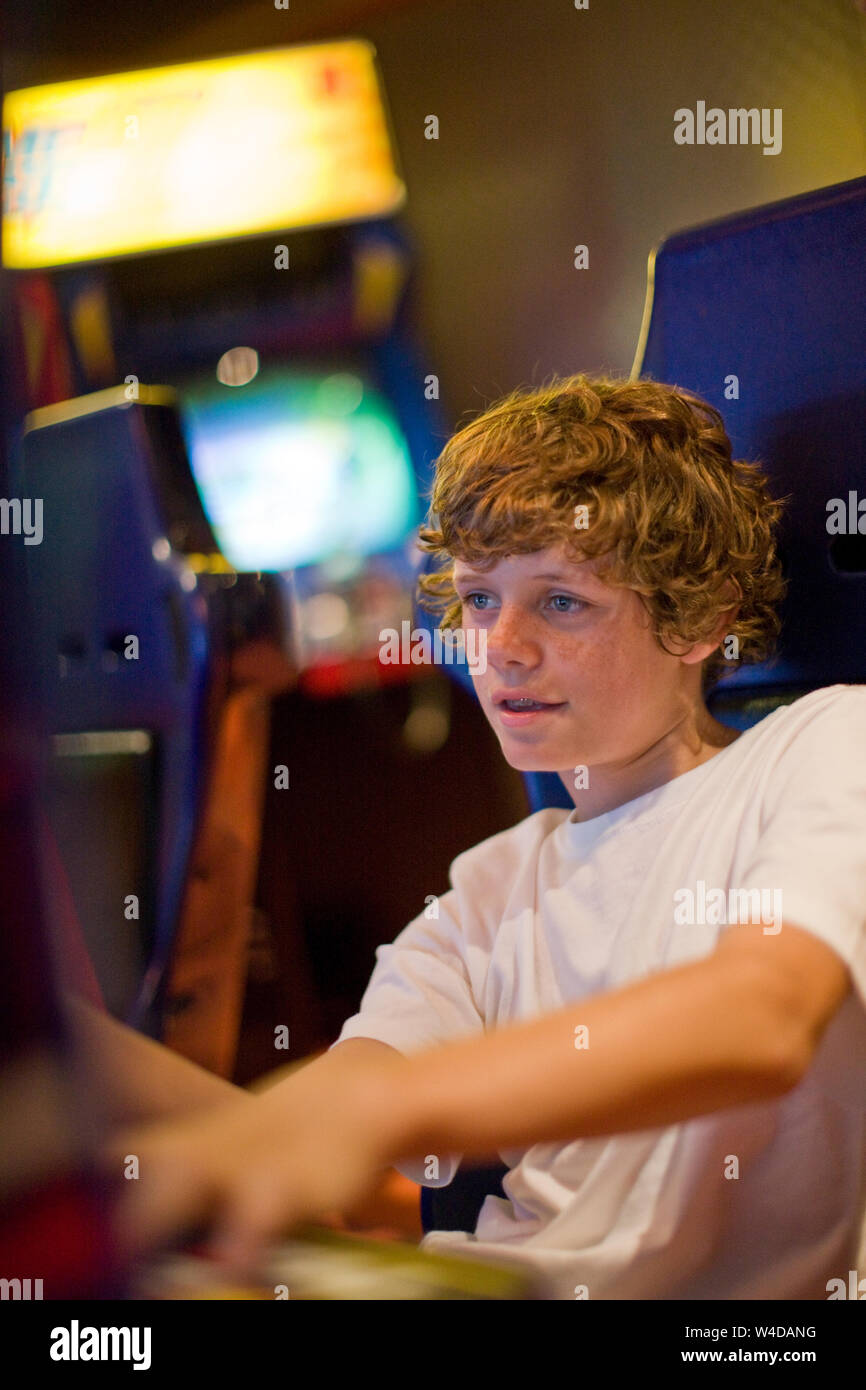 Teenage boy playing a video game inside a gaming arcade Stock Photo - Alamy