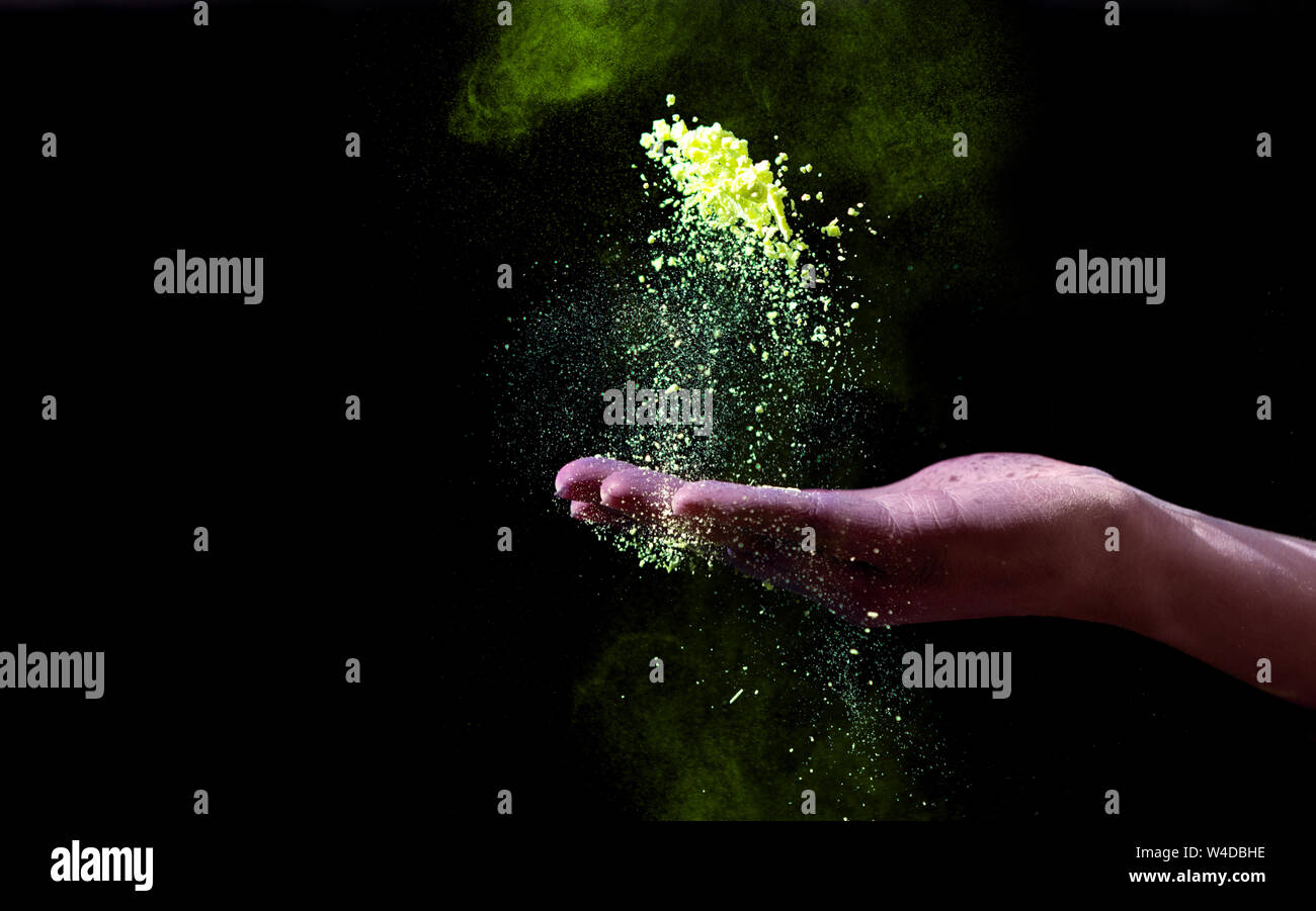 Hand holding yellow holi powder for color festival on black Stock Photo ...
