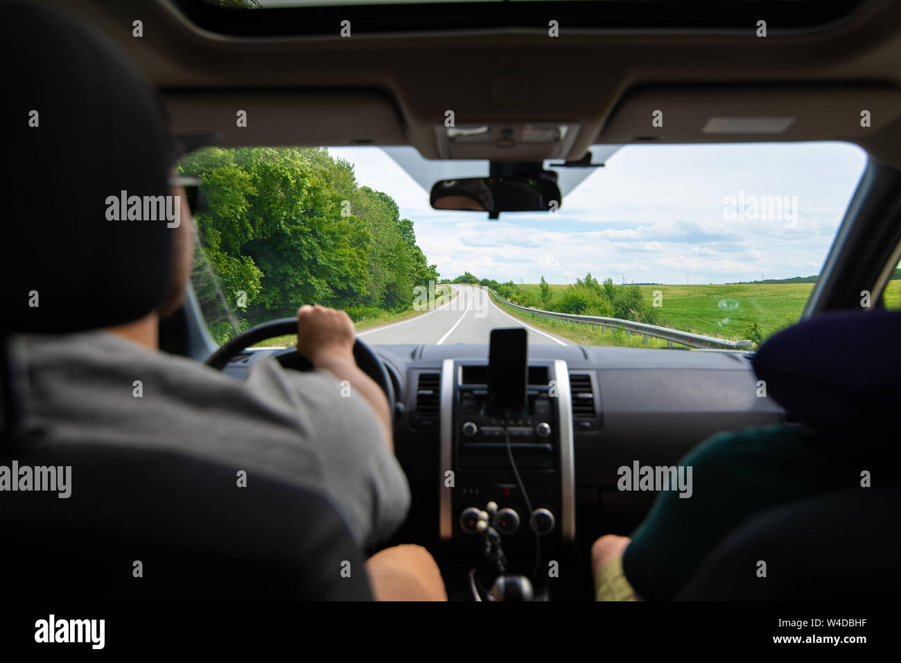 car travel concept view from inside young caucasian man driving car by ...