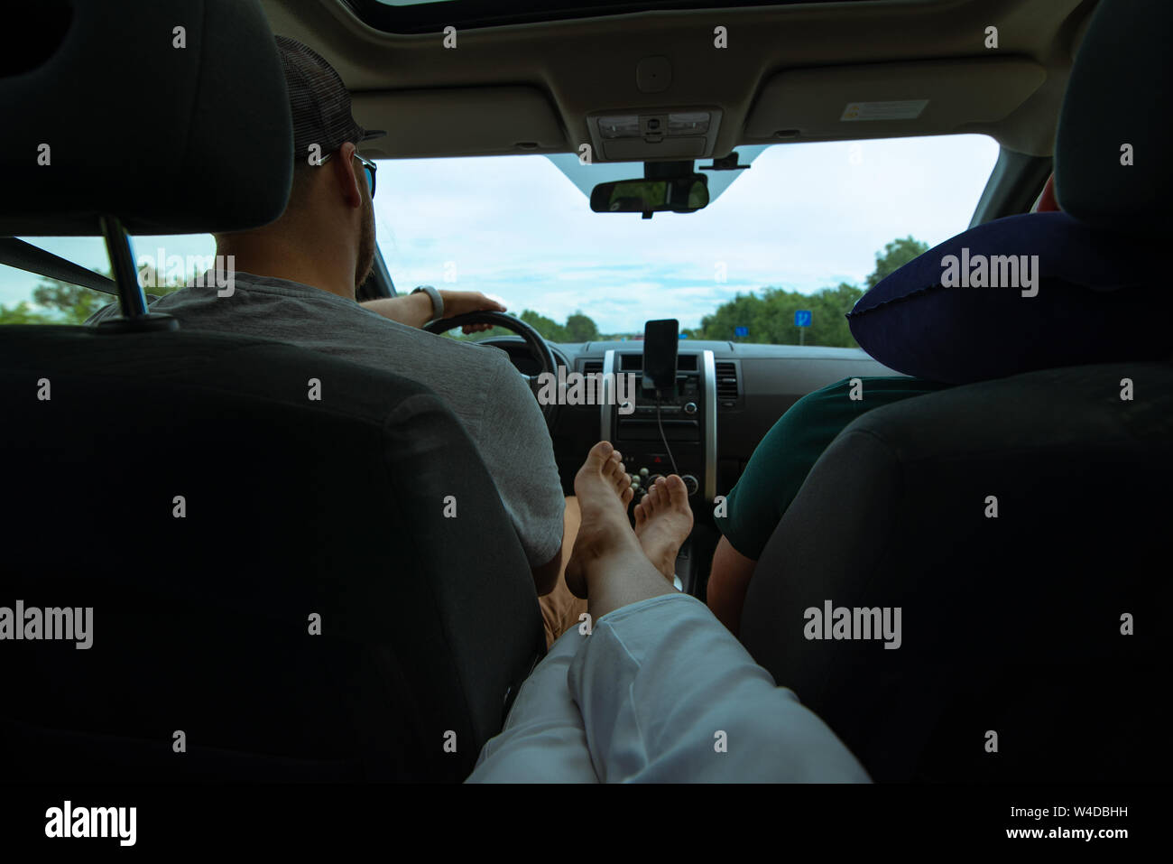 woman sitting at backseats of car put legs on armrest sunroof car ...