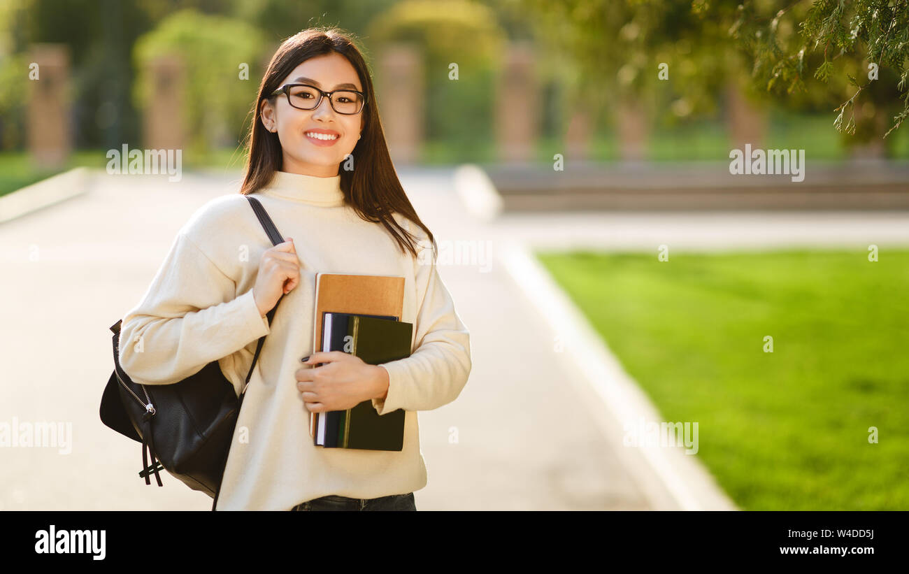 Asian student with backpack carrying books after study Stock Photo - Alamy