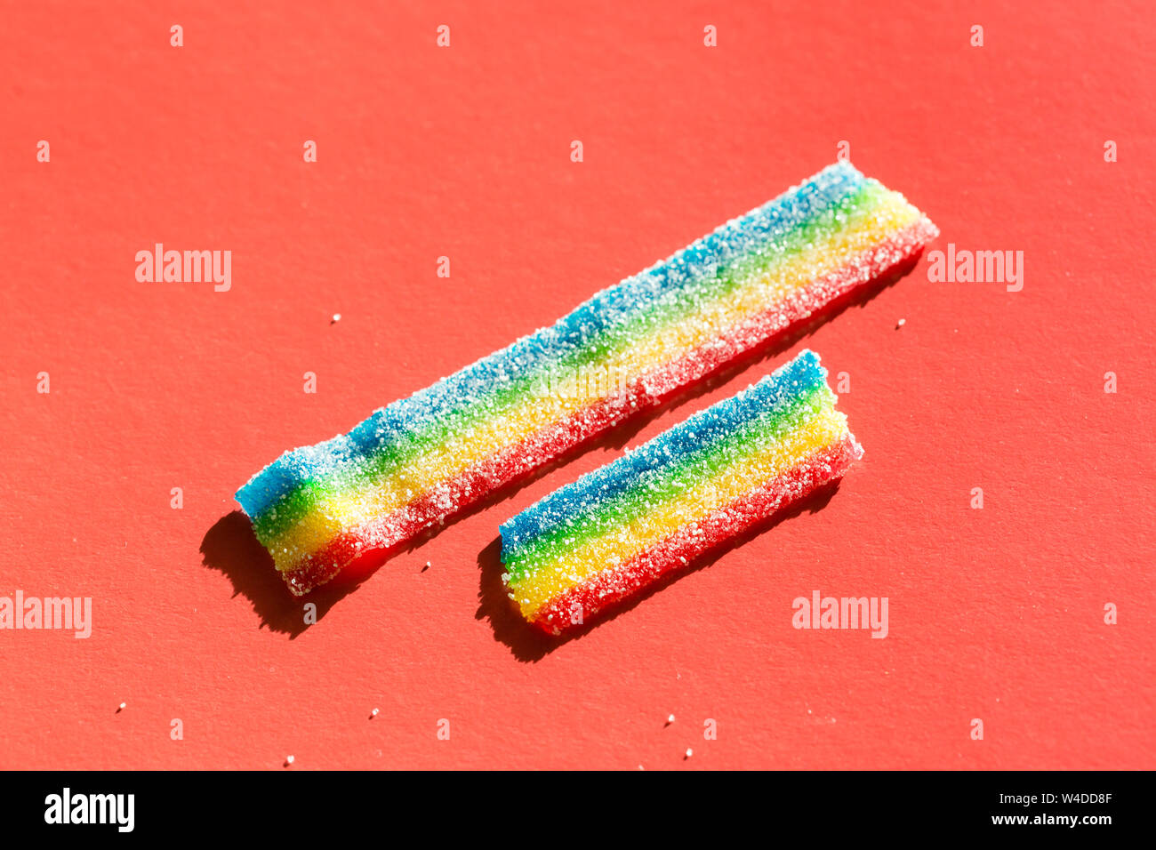 Colored marmalade in the sugar on the red background. Natural rainbow ...