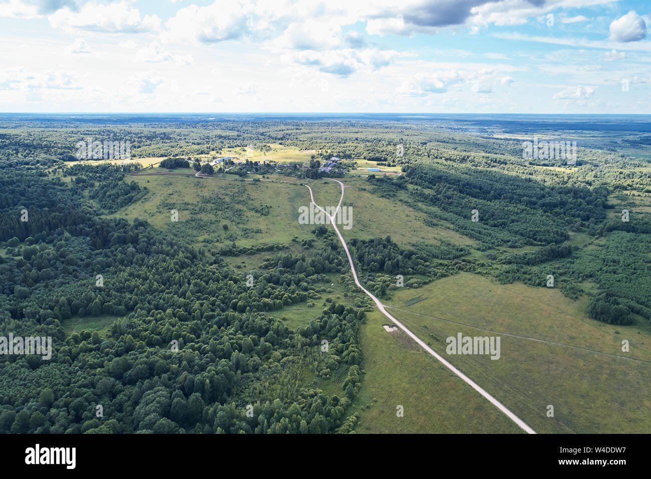 Aerial photography with a drone. Village with green forest, road and field Stock Photo - Alamy