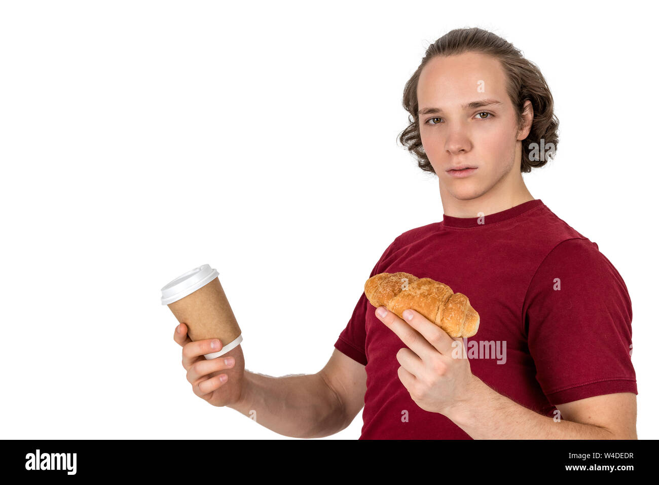 Young handsome man drink coffee and eating croissant. French breakfast ...