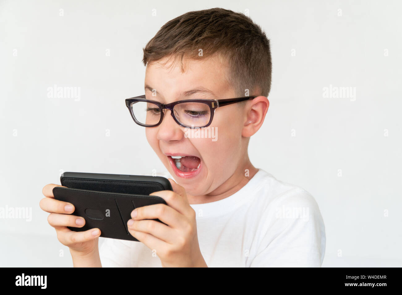 Boy watching his mobile phone with headset hi-res stock photography and ...