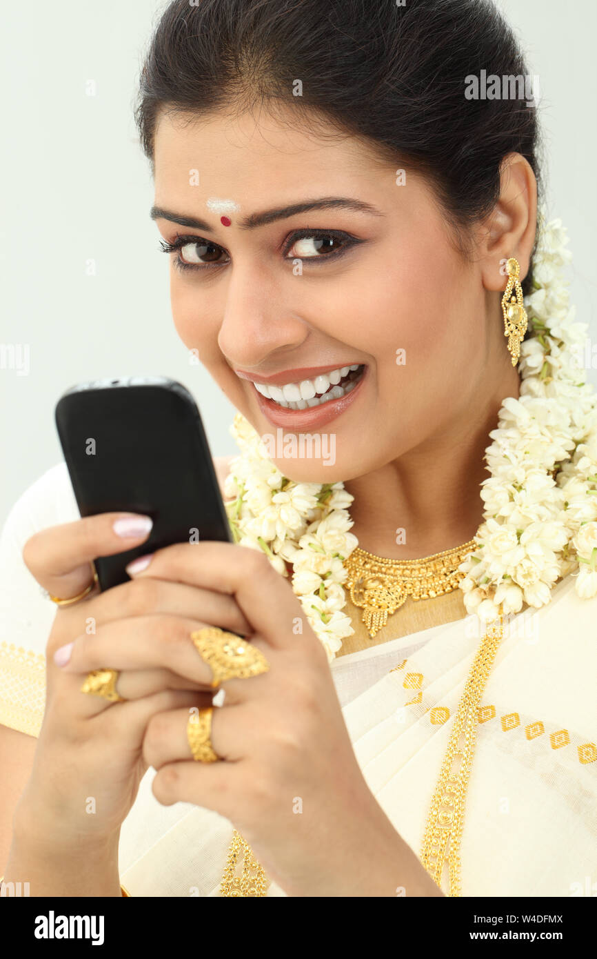 South Indian woman text messaging and smiling Stock Photo - Alamy